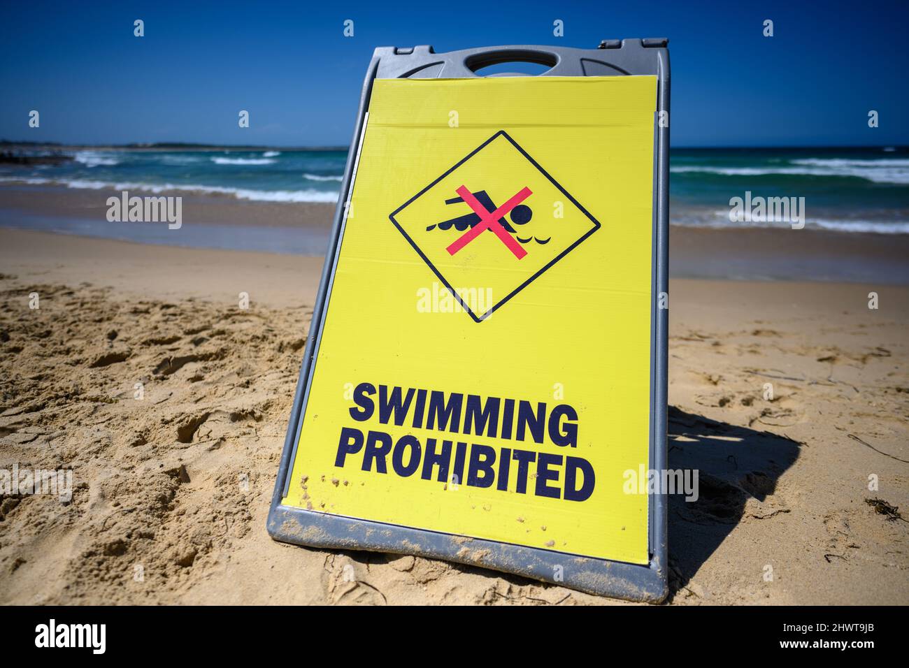 Yellow no swimming sign on a beach Stock Photo - Alamy