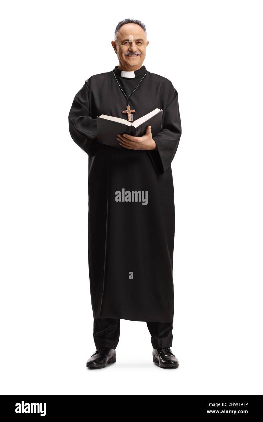 Full length portrait of a mature priest standing and holding open bible ...