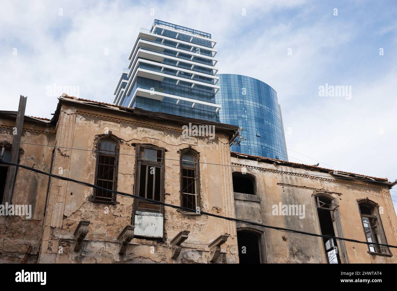 Old abandoned wrecked house and modern building at backgrounds. Tel ...