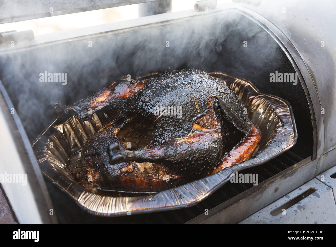 Smoked turkey cooking outdoor on a grill and smoker combination Stock ...