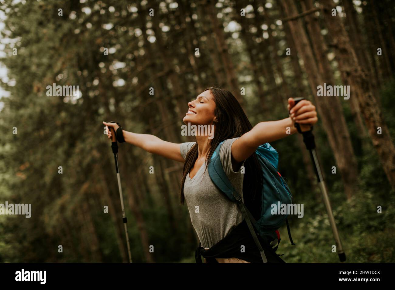 Pretty young female backpacker woman enjoying green beautiful forest ...