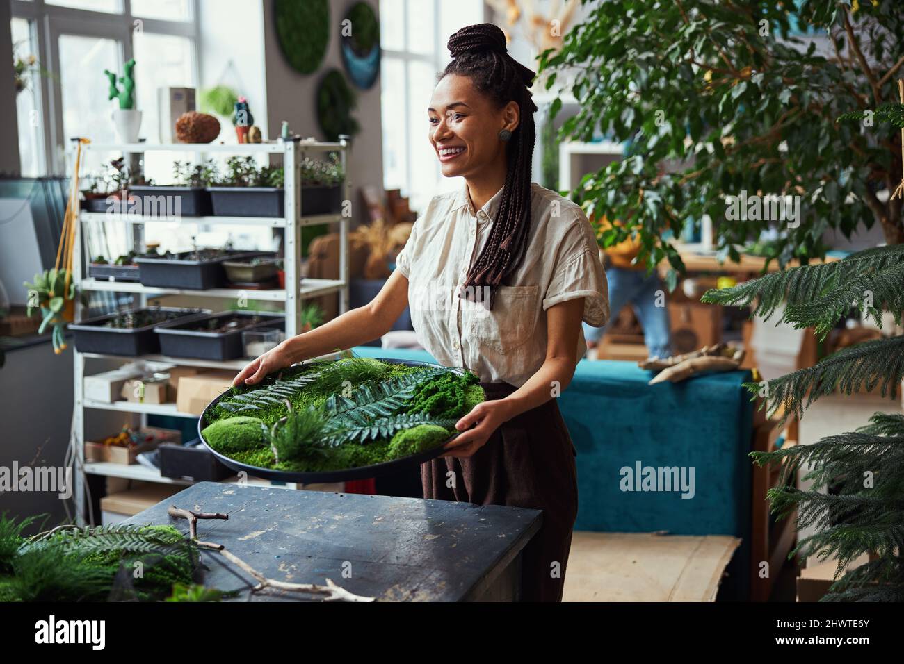 Happy beautiful florist with a moss art work Stock Photo - Alamy