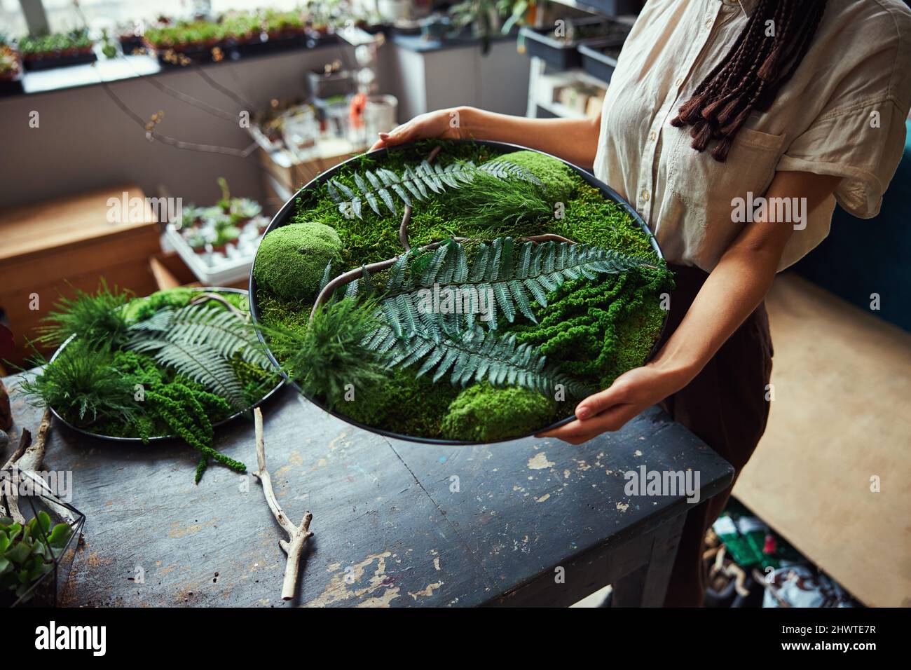 Professional florist showing her moss art work Stock Photo - Alamy