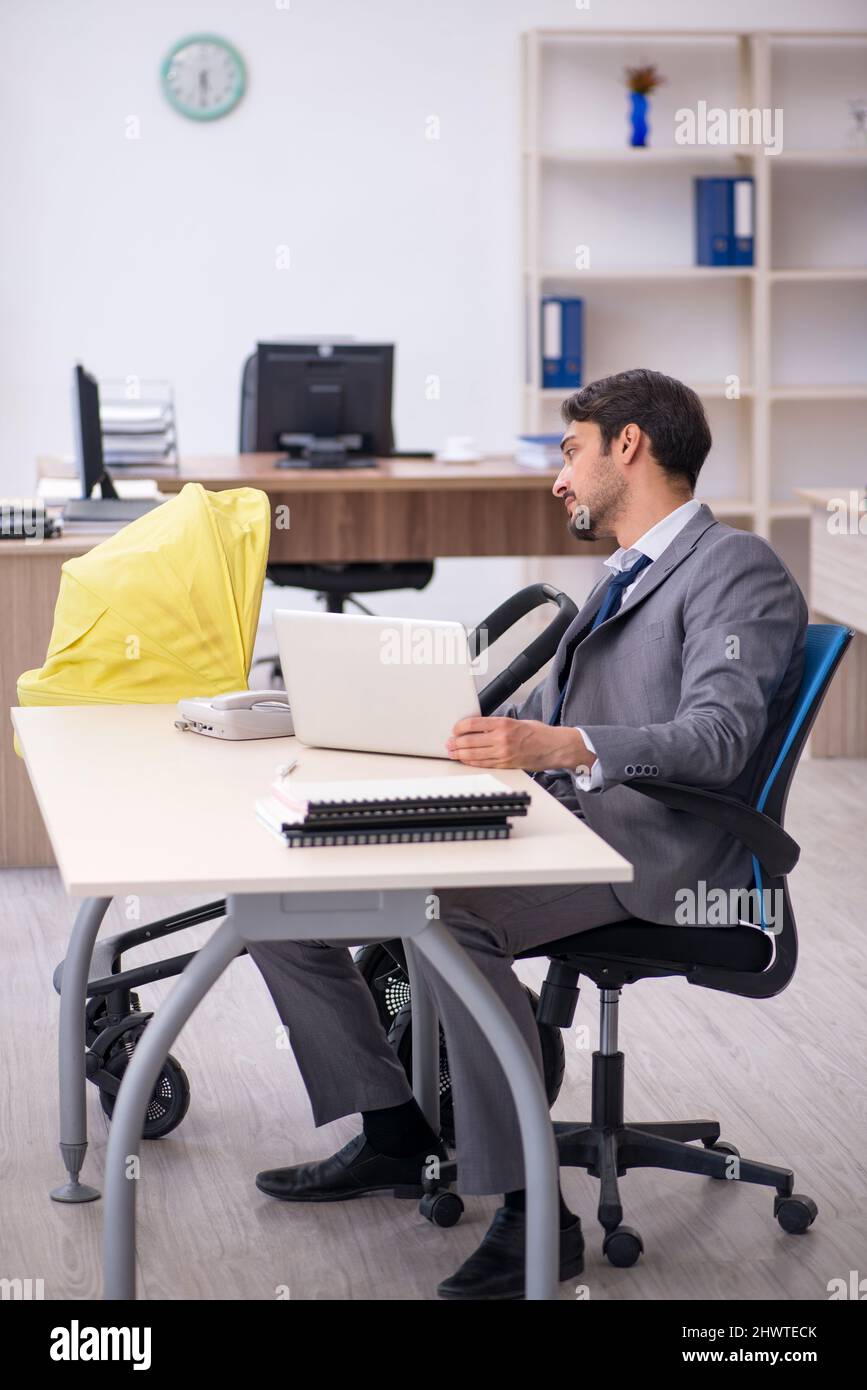 Young businessman employee looking after new born in the office Stock ...