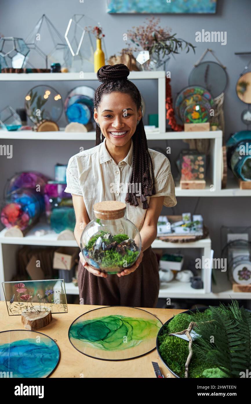 Pleased lady florist with a closed florarium looking ahead Stock Photo ...