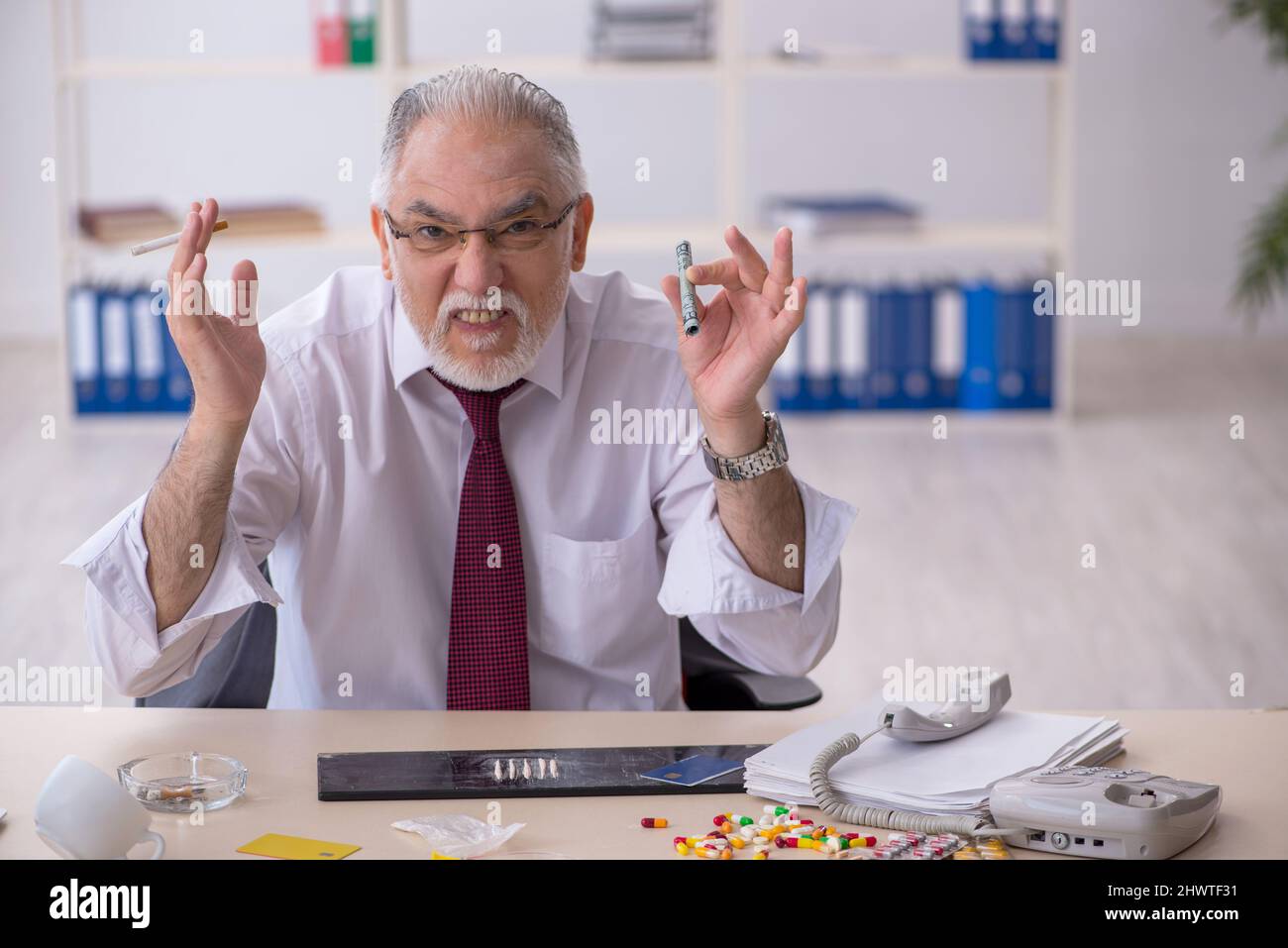 Old male drug addicted employee sitting at workplace Stock Photo - Alamy