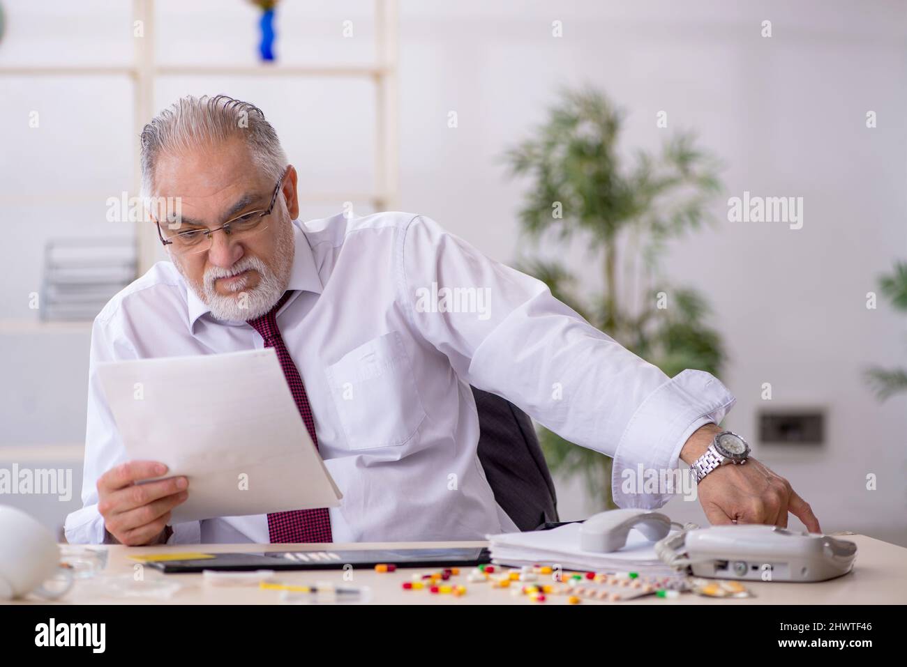 Old male drug addicted employee sitting at workplace Stock Photo - Alamy