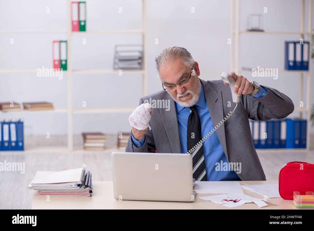 Old businessman employee cutting his hand at workplace Stock Photo - Alamy