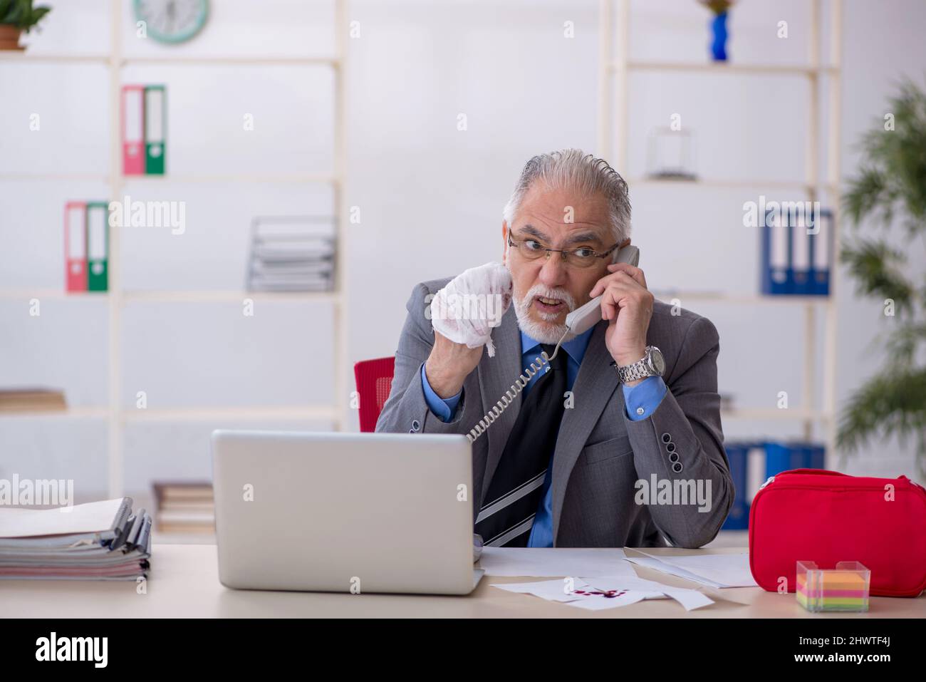 Old businessman employee cutting his hand at workplace Stock Photo - Alamy