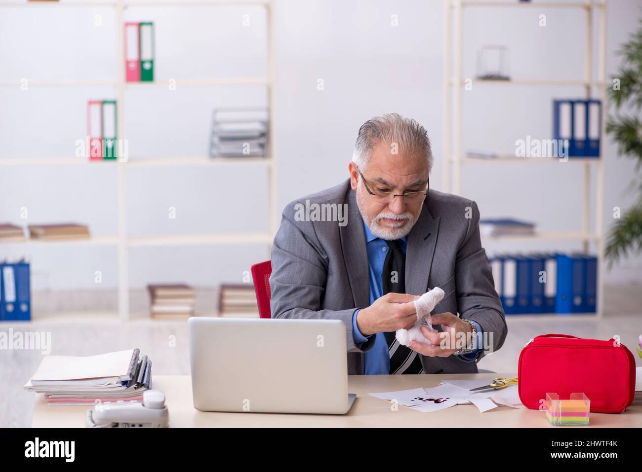 Old businessman employee cutting his hand at workplace Stock Photo - Alamy