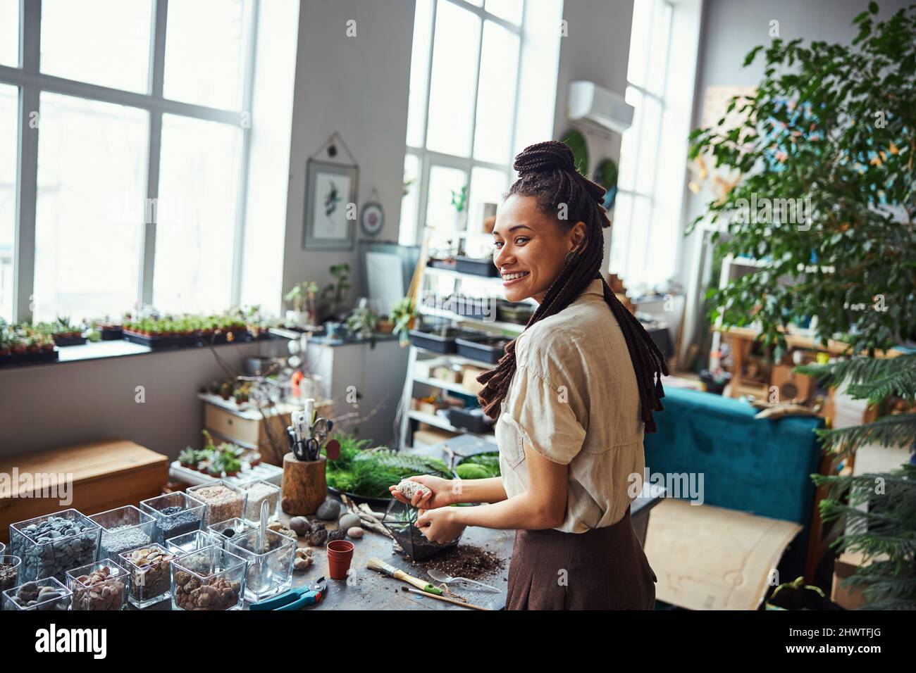 Pleased florist using natural stones for a florarium decoration Stock ...