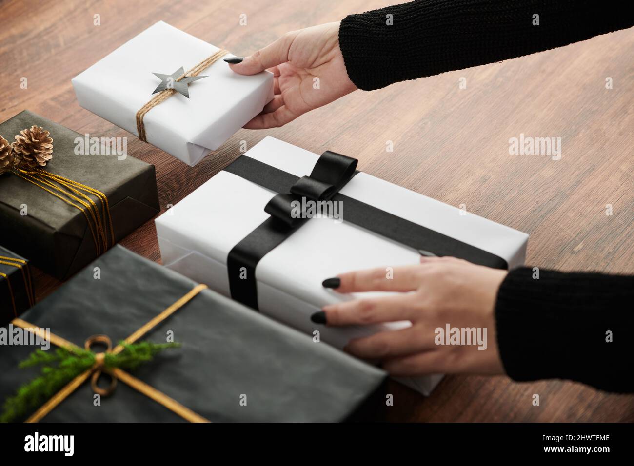 Close-up image of woman putting wrapped presents she bought for friends ...