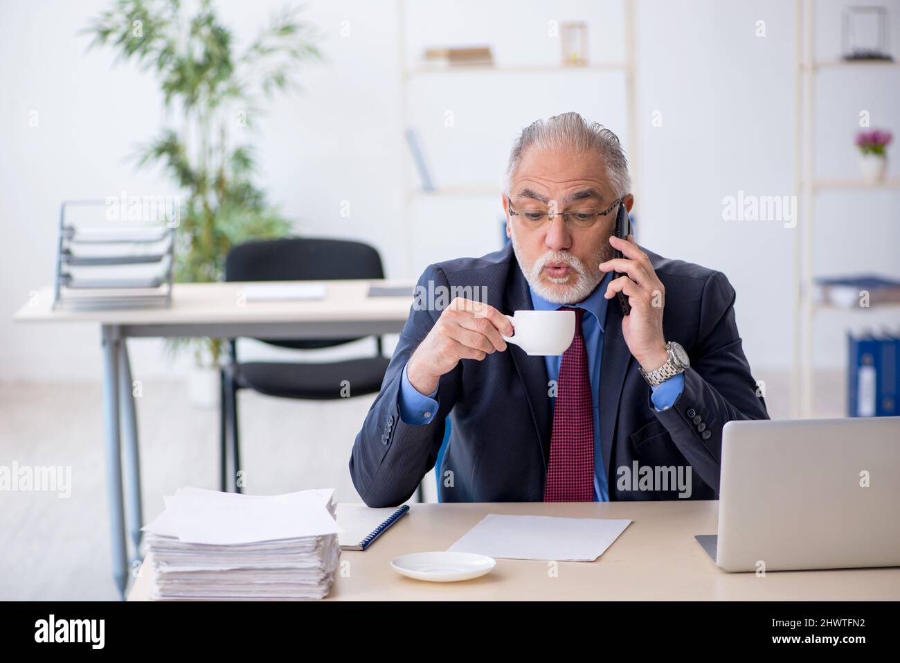 Old businessman employee having breakfast at workplace Stock Photo - Alamy