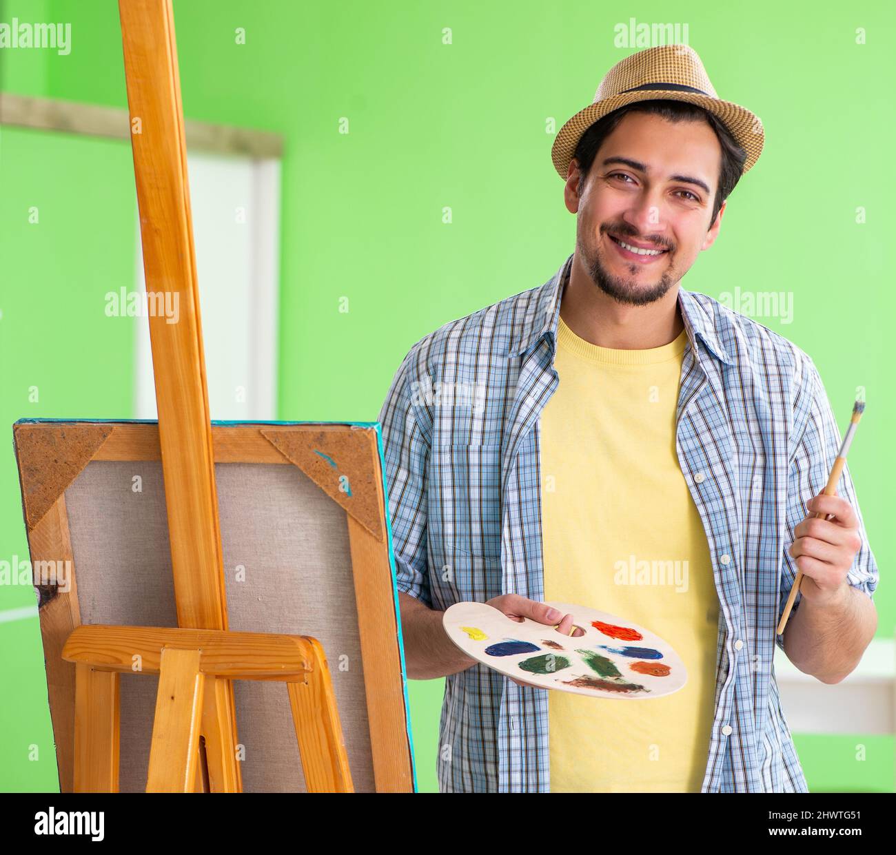 The young male artist working on new painting in his studio Stock Photo ...