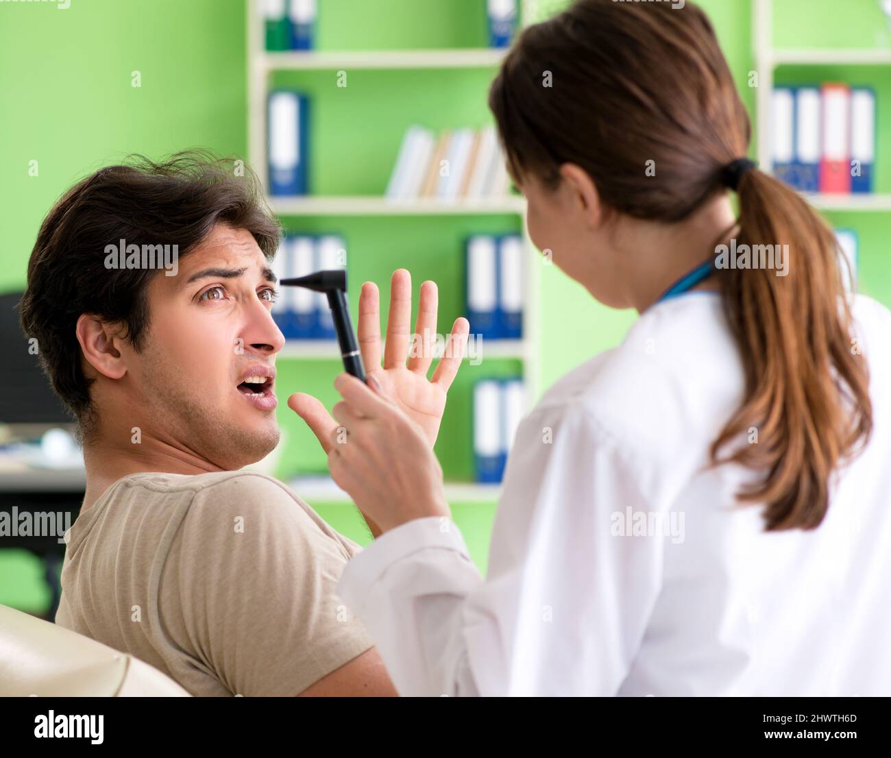 The female doctor checking patient's ear during medical examination ...