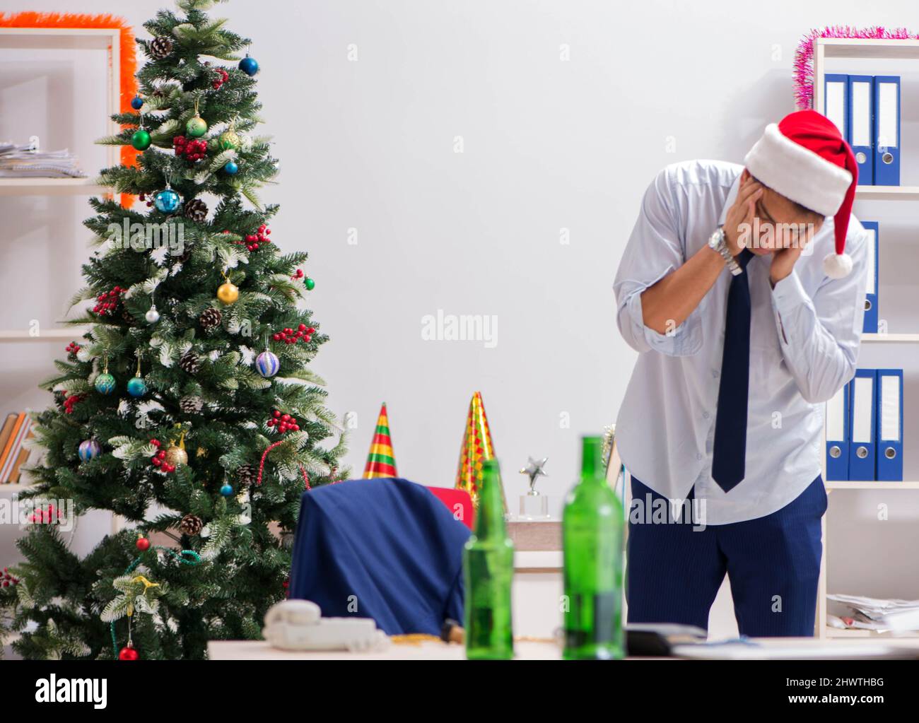 The young handsome employee celebrating christmas at workplace Stock ...