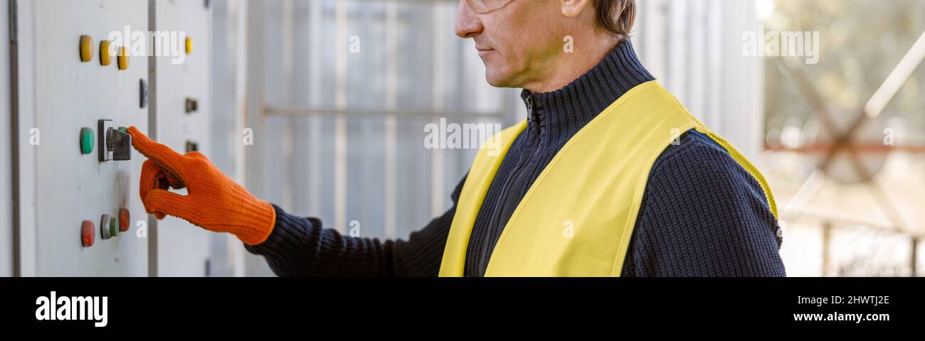 Male engineer using electric control box at factory Stock Photo - Alamy