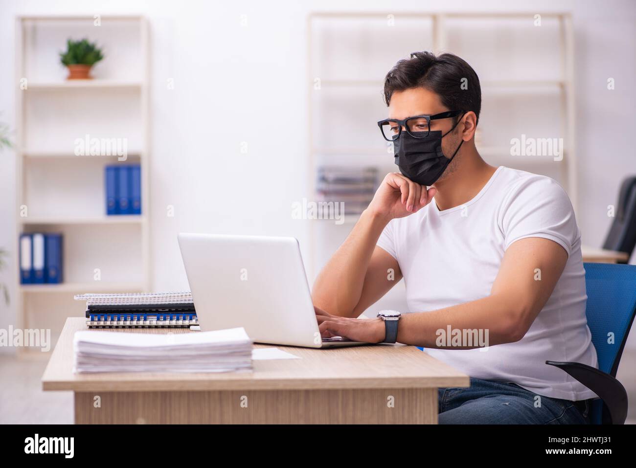 Young student employee working at workplace during pandemic Stock Photo ...