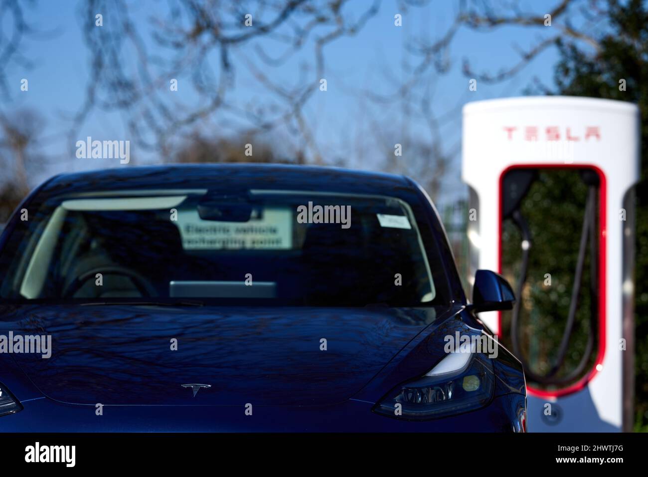 A Tesla vehicle being charged at a Tesla supercharger point in London ...