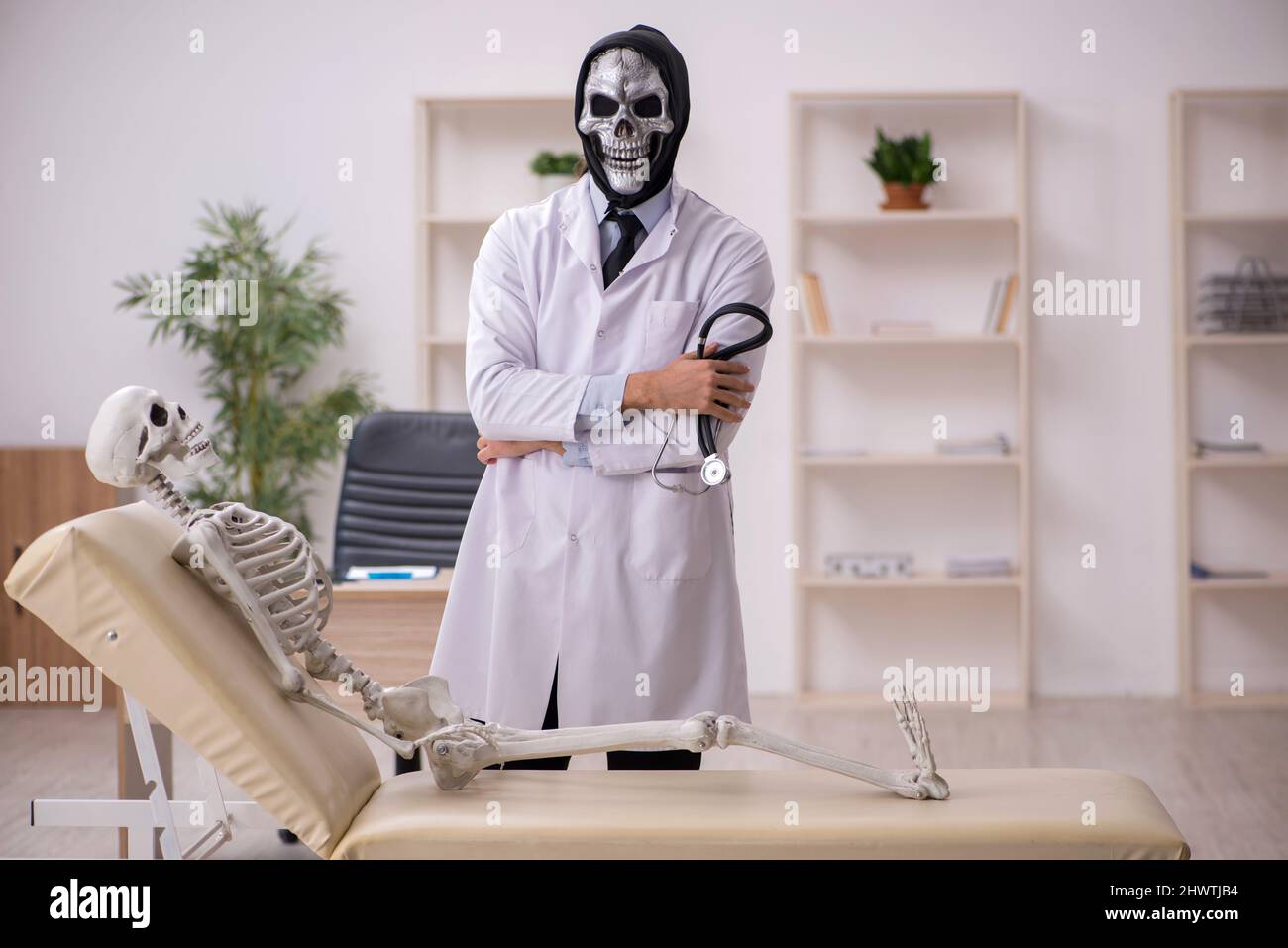 Devil doctor examining skeleton patient in the clinic Stock Photo - Alamy