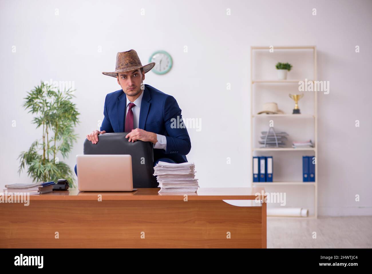 Young cowboy employee working at workplace Stock Photo - Alamy