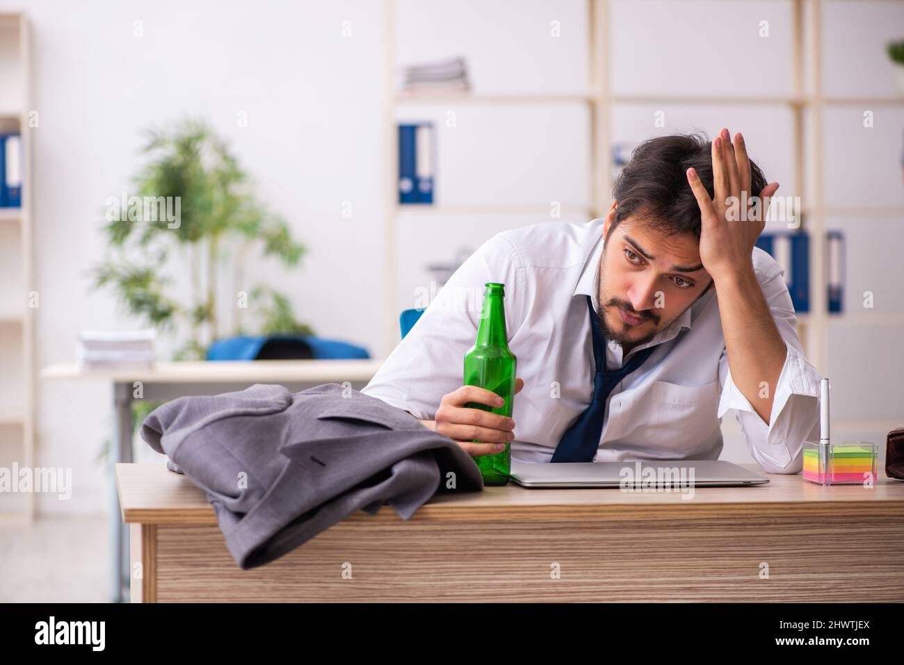 Male alcohol addicted employee sitting in the office Stock Photo - Alamy