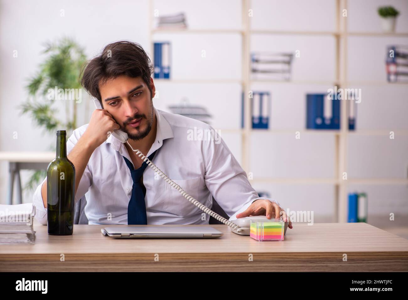 Male alcohol addicted employee sitting in the office Stock Photo - Alamy