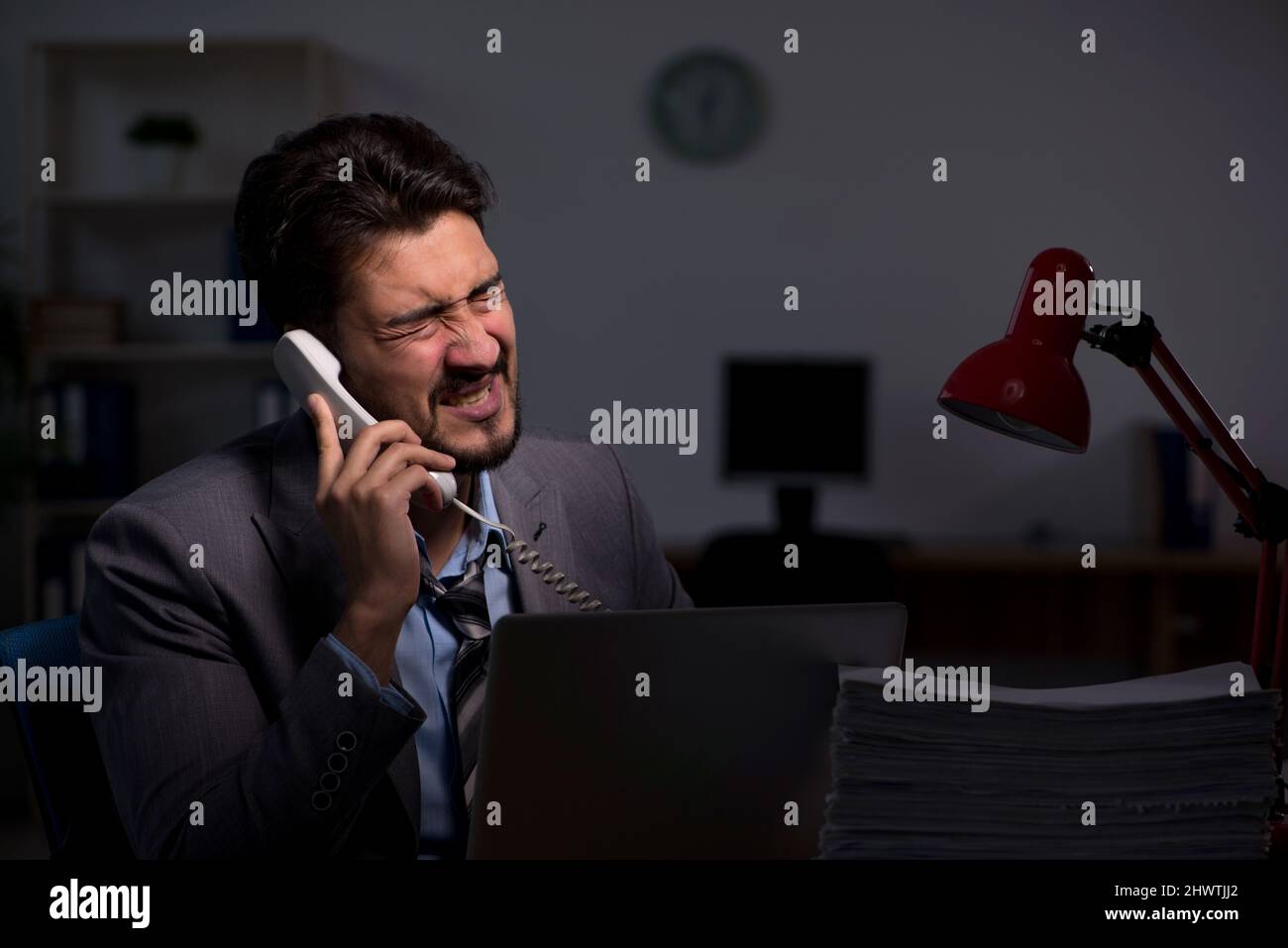 Young employee working late in the office Stock Photo - Alamy