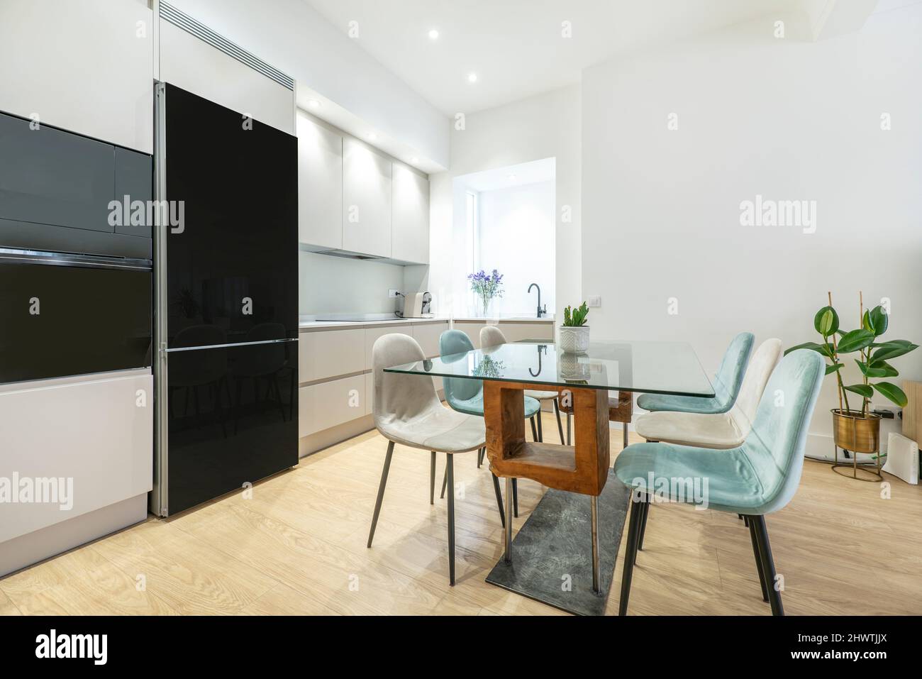 Kitchen with smooth gray furniture without handles and black appliances ...