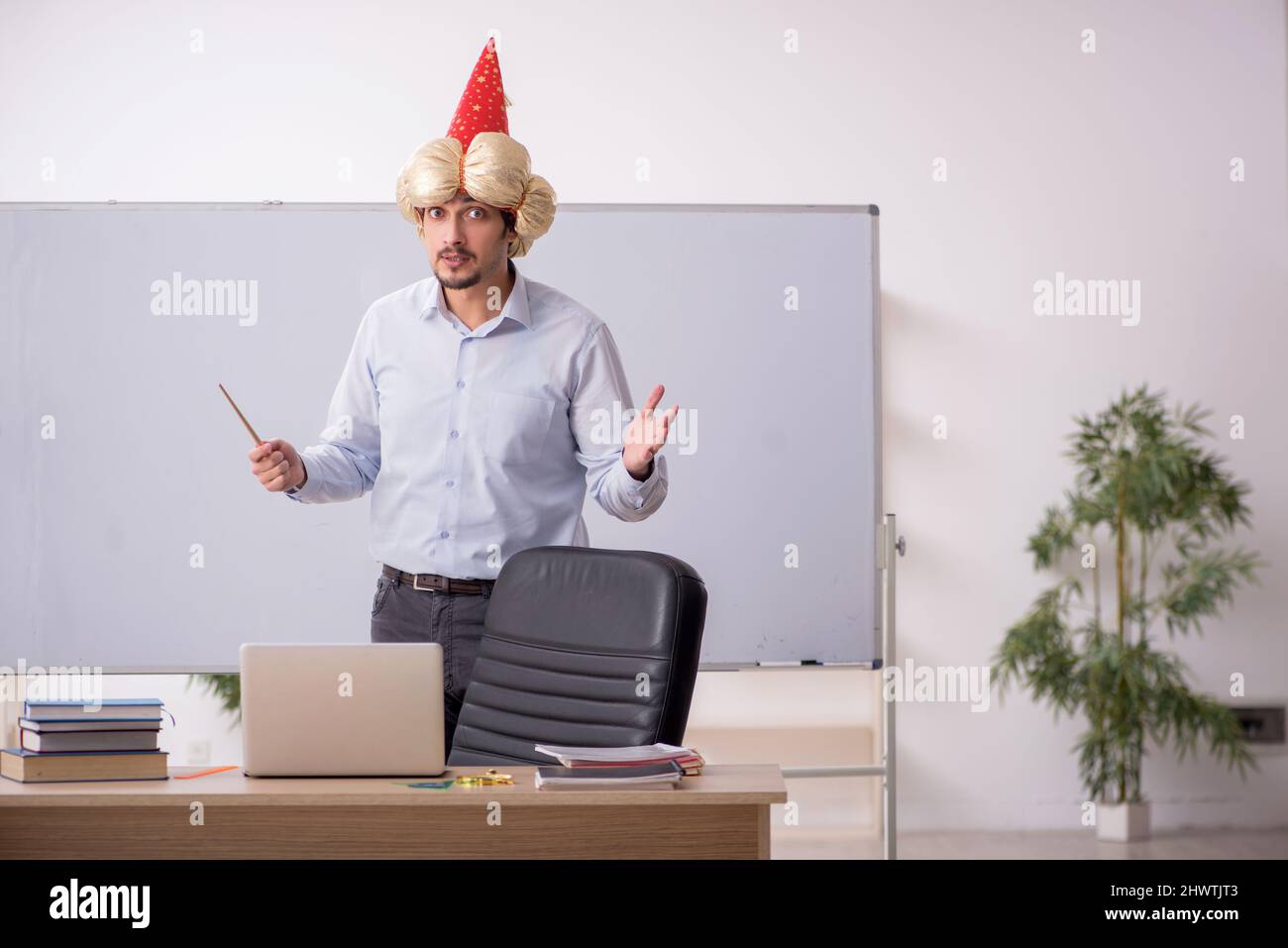 Funny young teacher magician in the classroom Stock Photo - Alamy