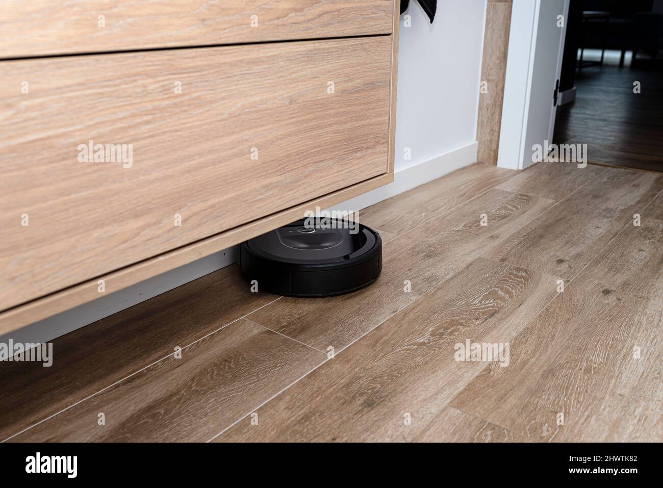 A modern robotic vacuum cleaner cleans the ceramic tiles in the ...