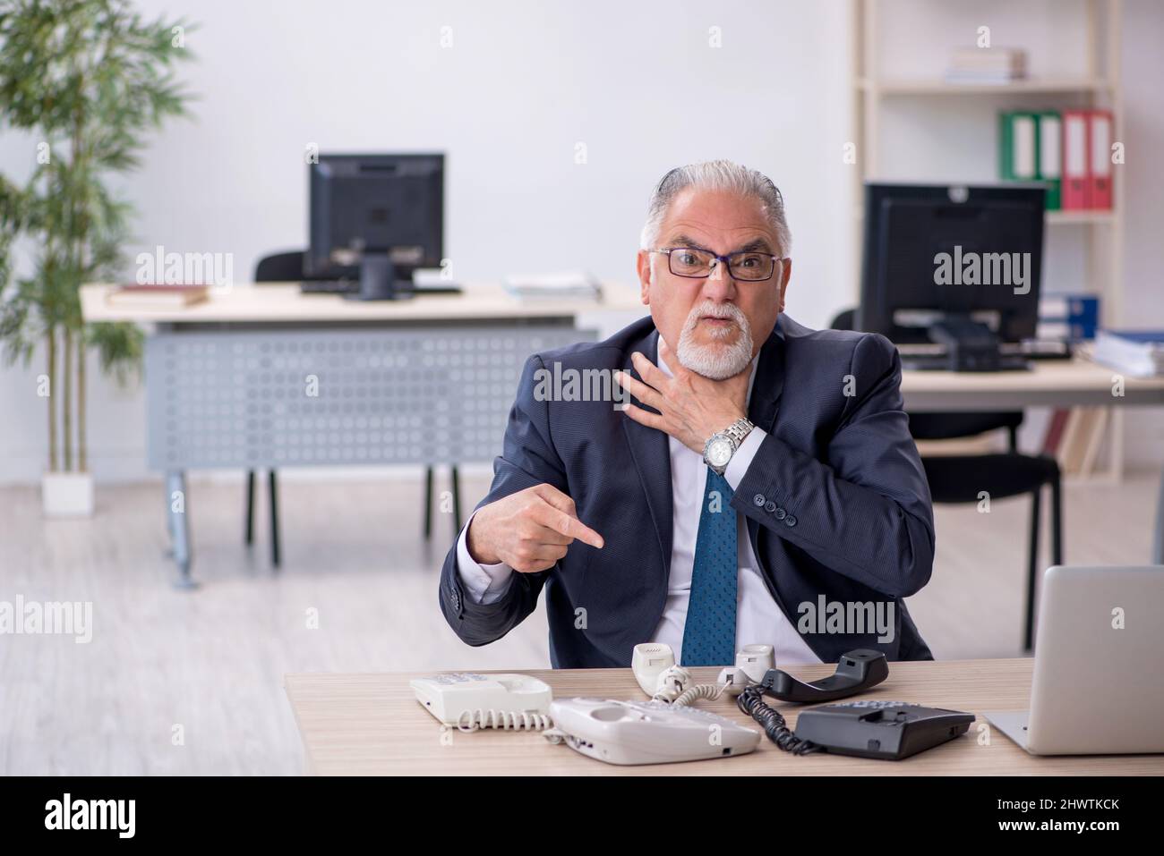Old businessman employee speaking on the phone in the office Stock ...