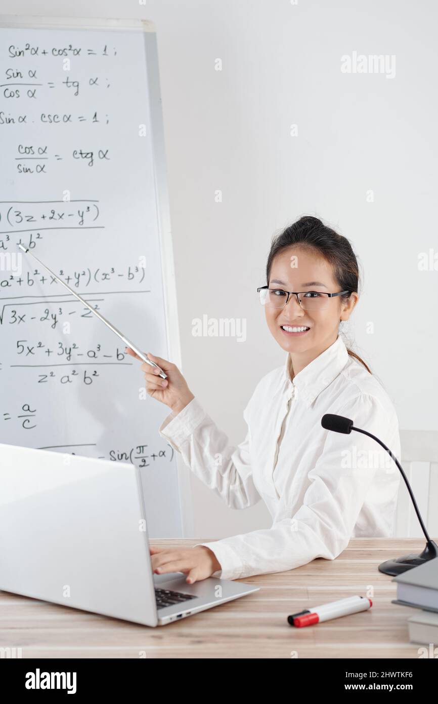 Smiling school teacher recording online lesson for students and ...