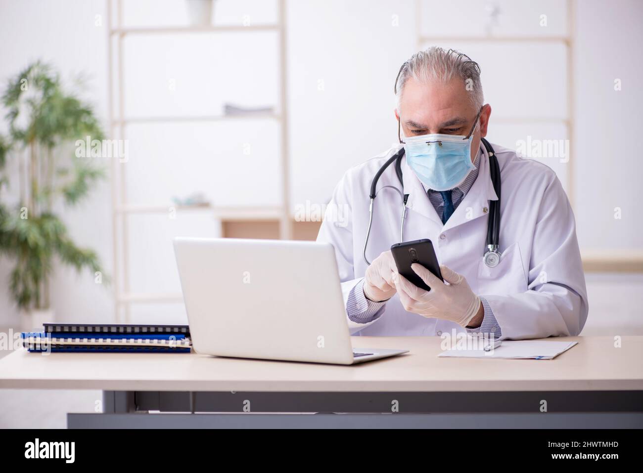 Old doctor working in the clinic Stock Photo - Alamy