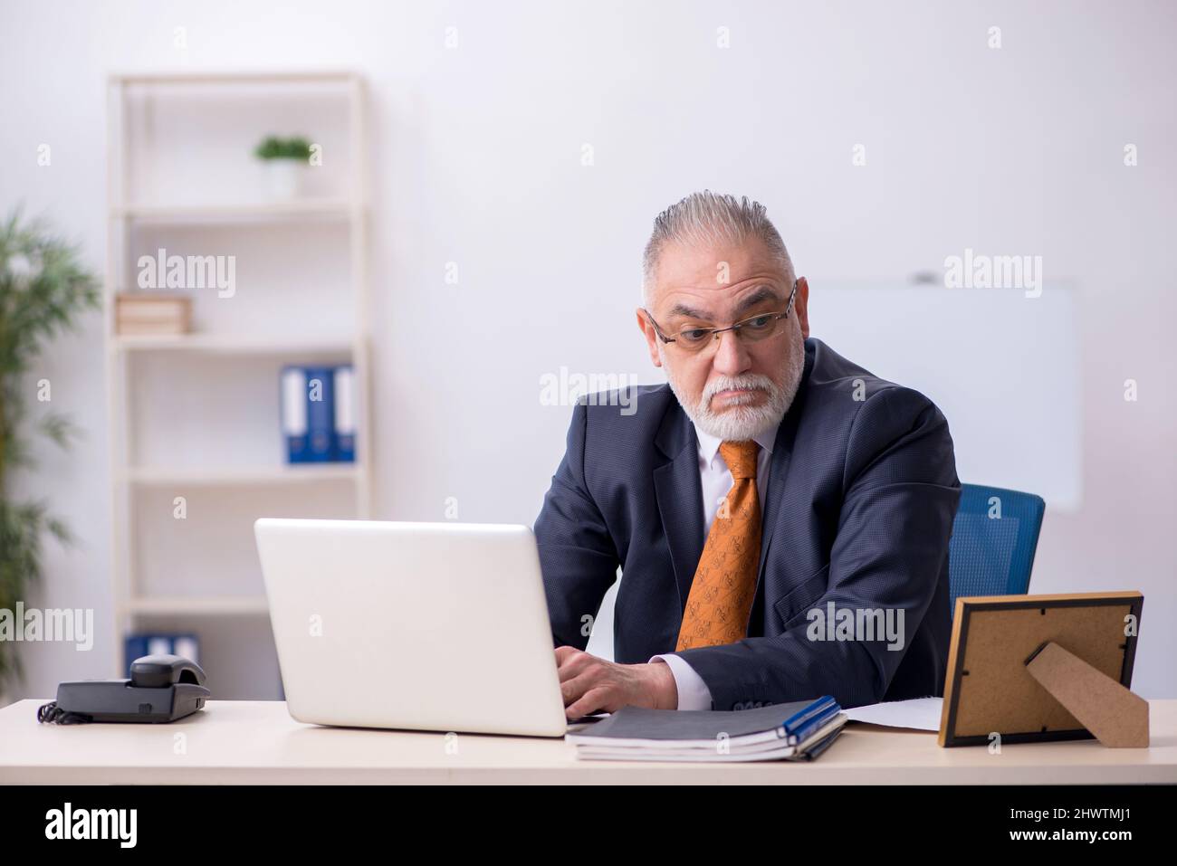 Old businessman employee missing his wife at workplace Stock Photo - Alamy