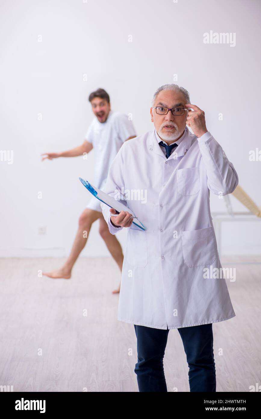 Old doctor psychiatrist examining young male patient Stock Photo - Alamy