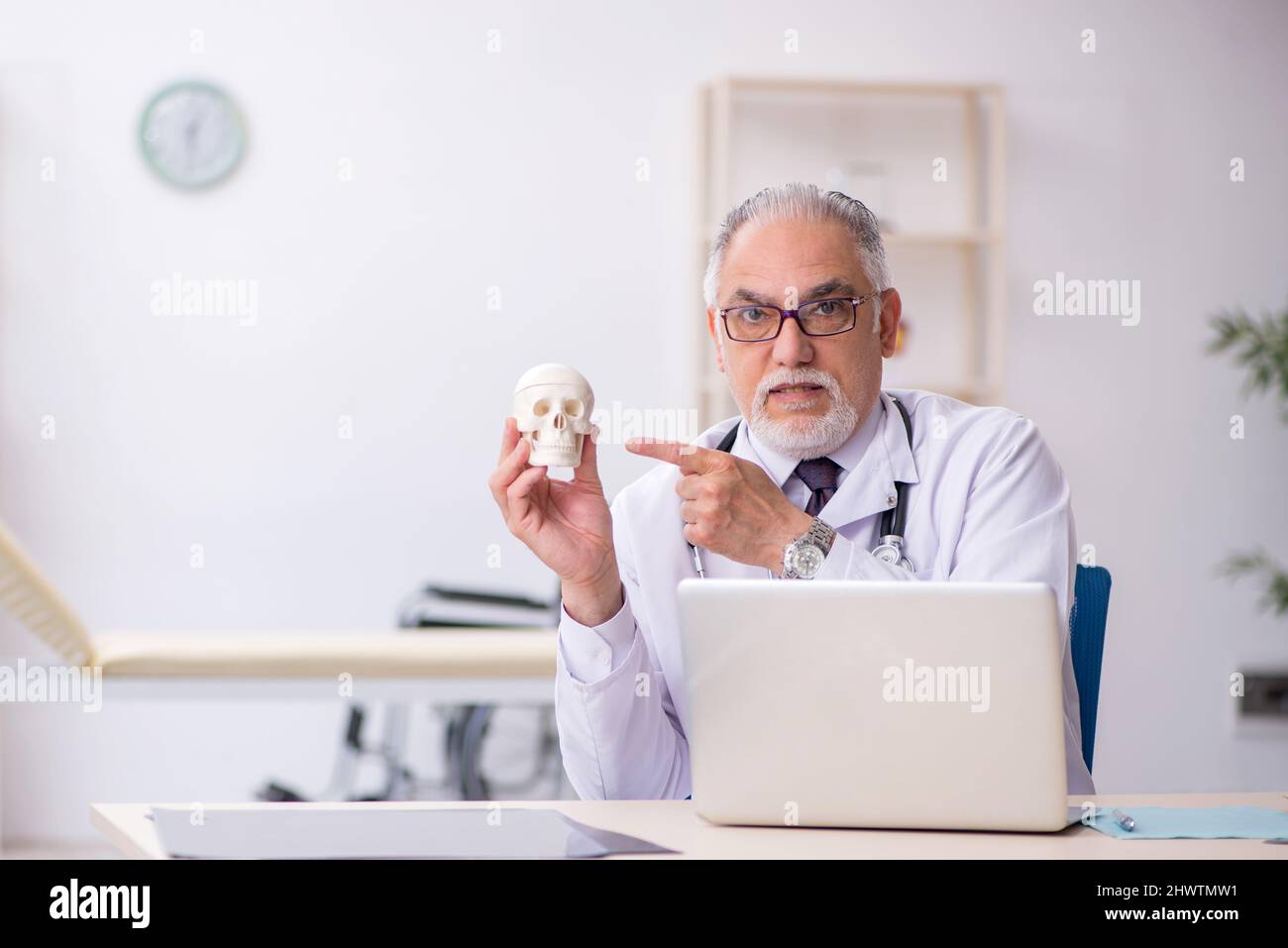 Old doctor demonstrating human skull Stock Photo - Alamy