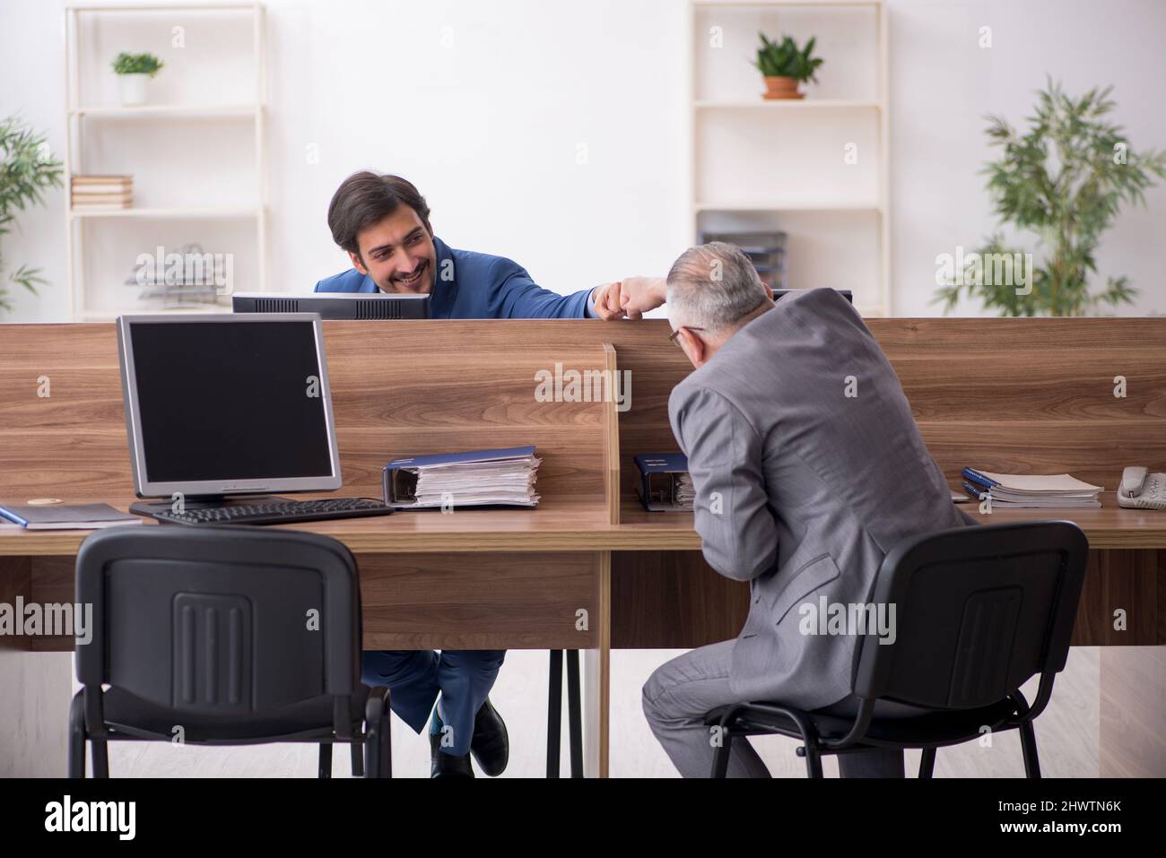 Two male employees working at workplace Stock Photo - Alamy
