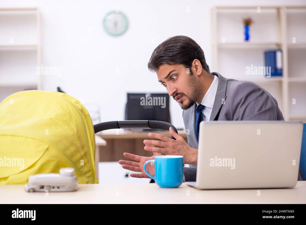 Young businessman employee looking after new born in the office Stock ...