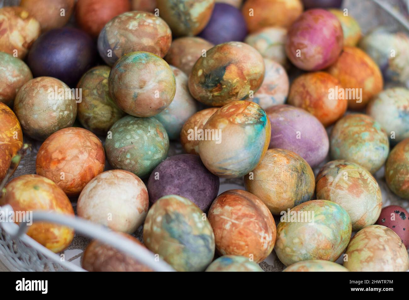 Colorful Easter eggs in pastel tones in big quantity heaped in white ...