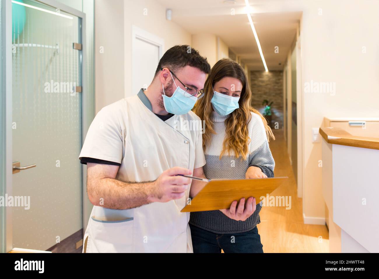 Nurse explaining notes to female patient in health center Stock Photo ...