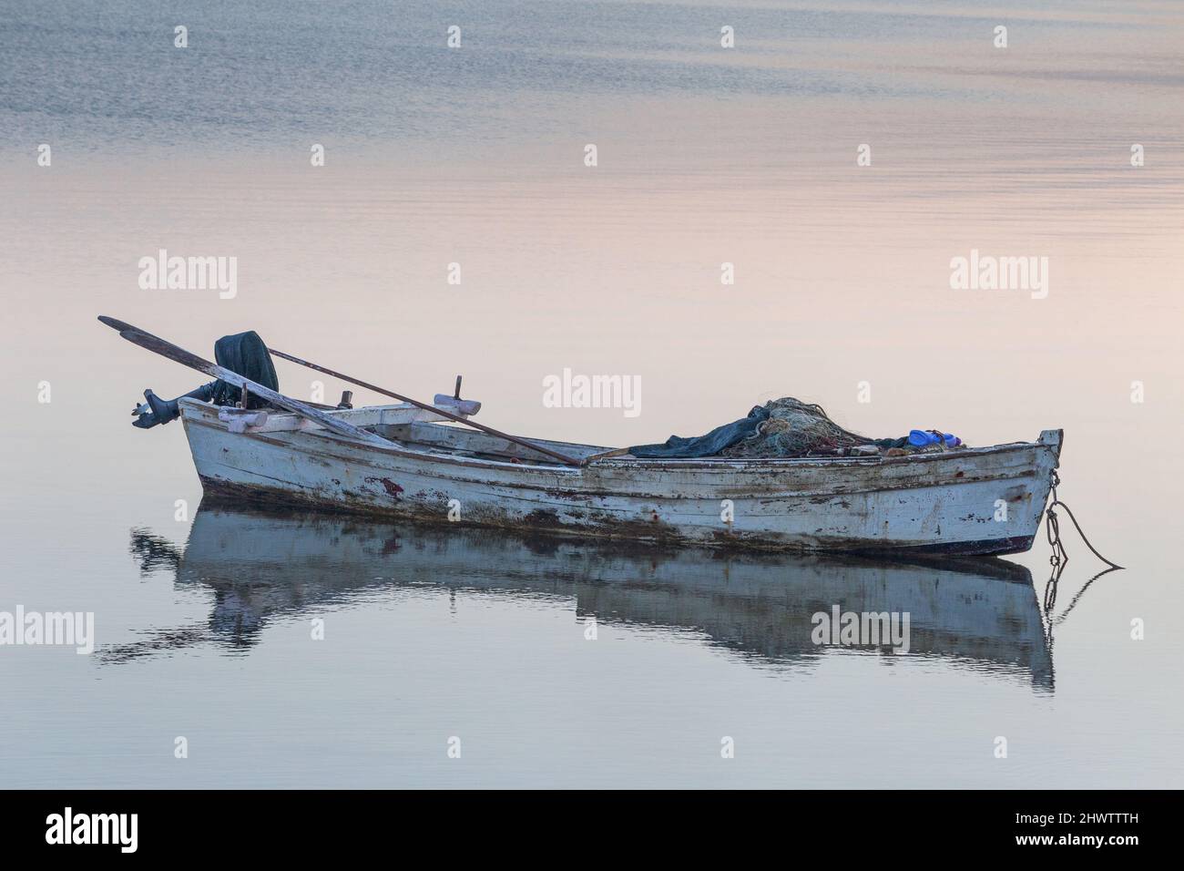 Old fishing small boat anchored at sea Stock Photo - Alamy