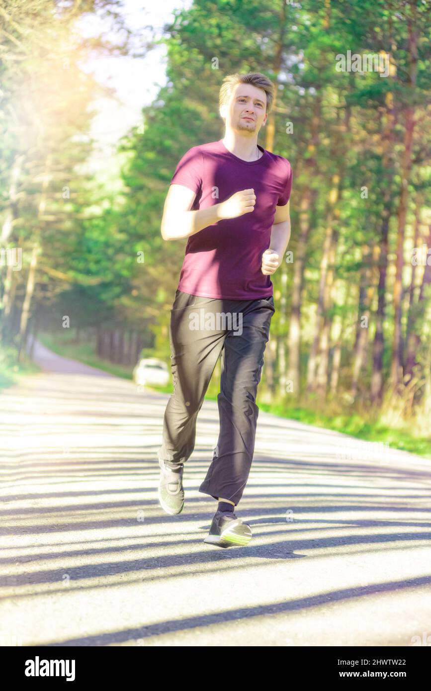 Running man jogging in city park at beautiful summer day. Sport fitness ...