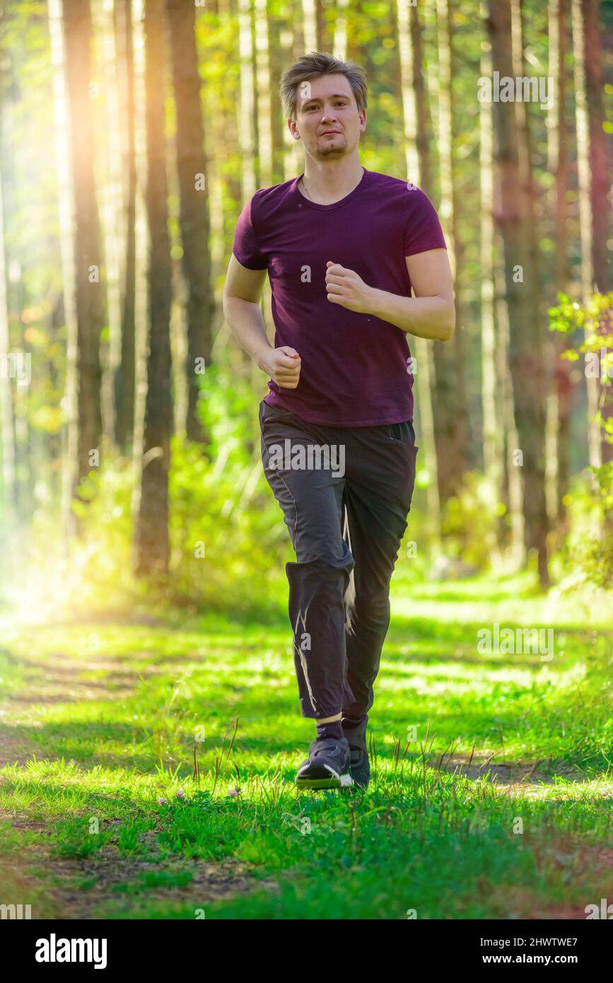 Running man jogging in city park at beautiful summer day. Sport fitness ...