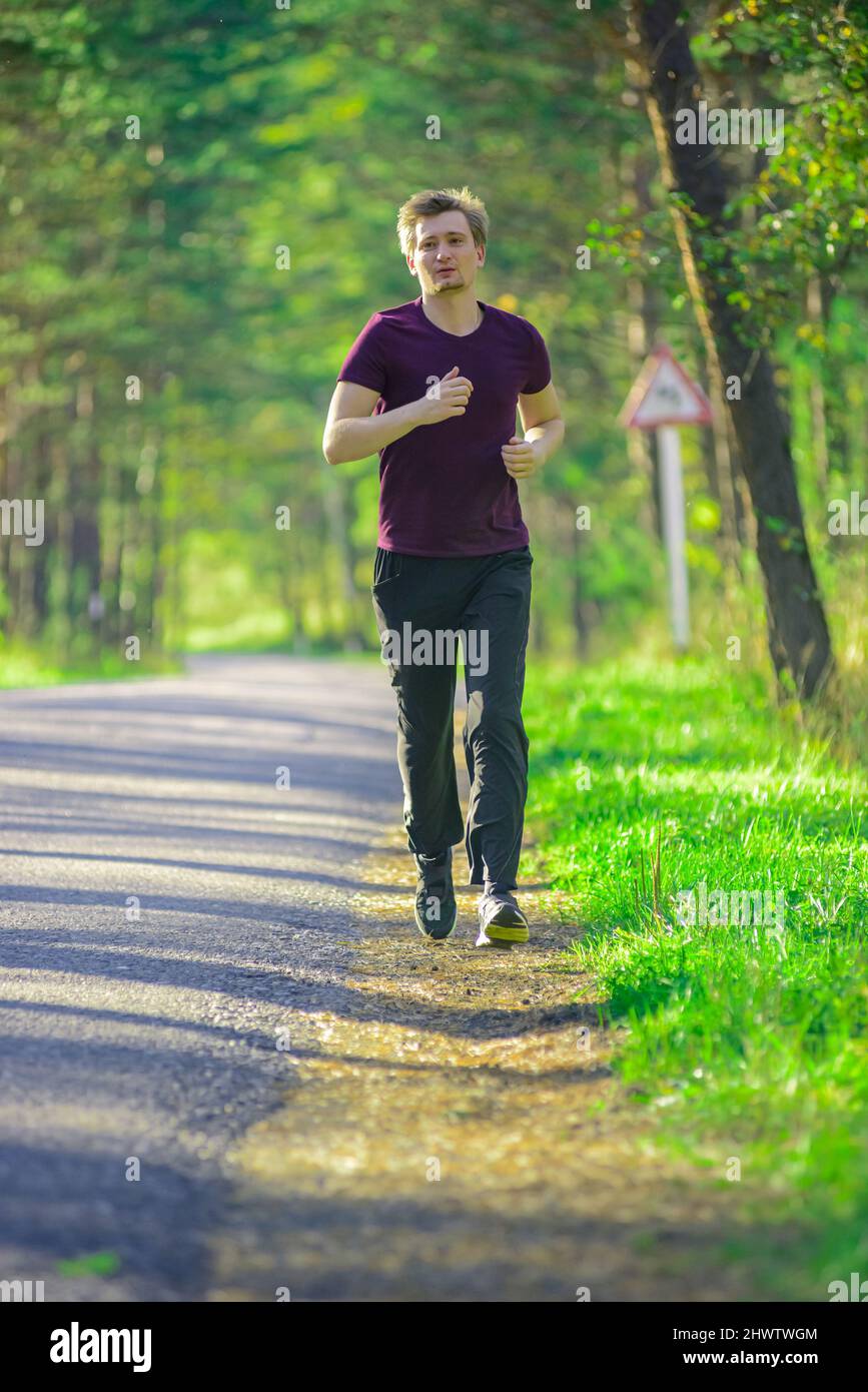 Running man jogging in city park at beautiful summer day. Sport fitness ...