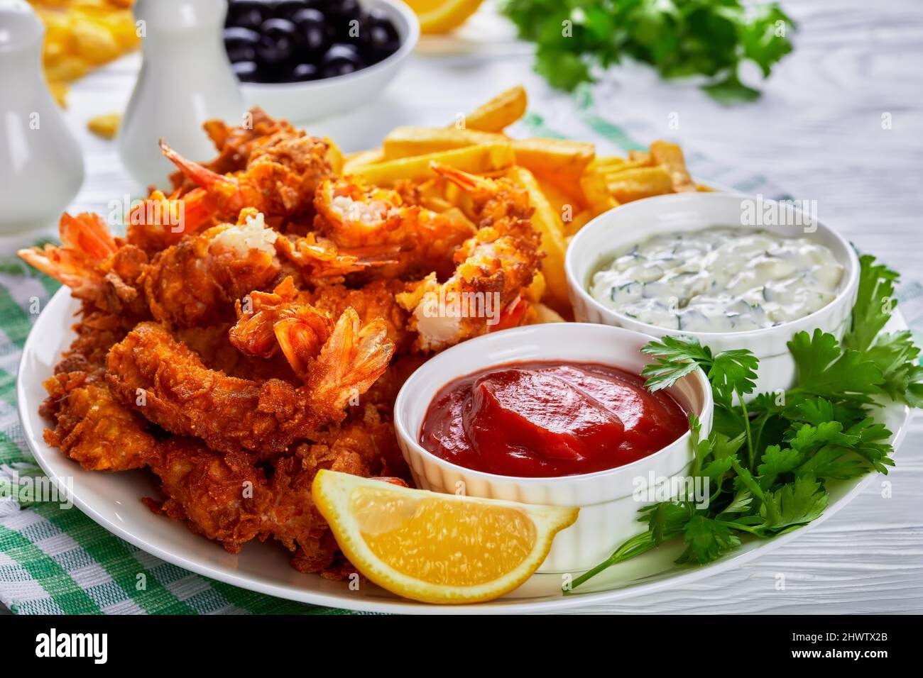 breaded and deep fried prawn tails with potato fries, tomato sauce and ...