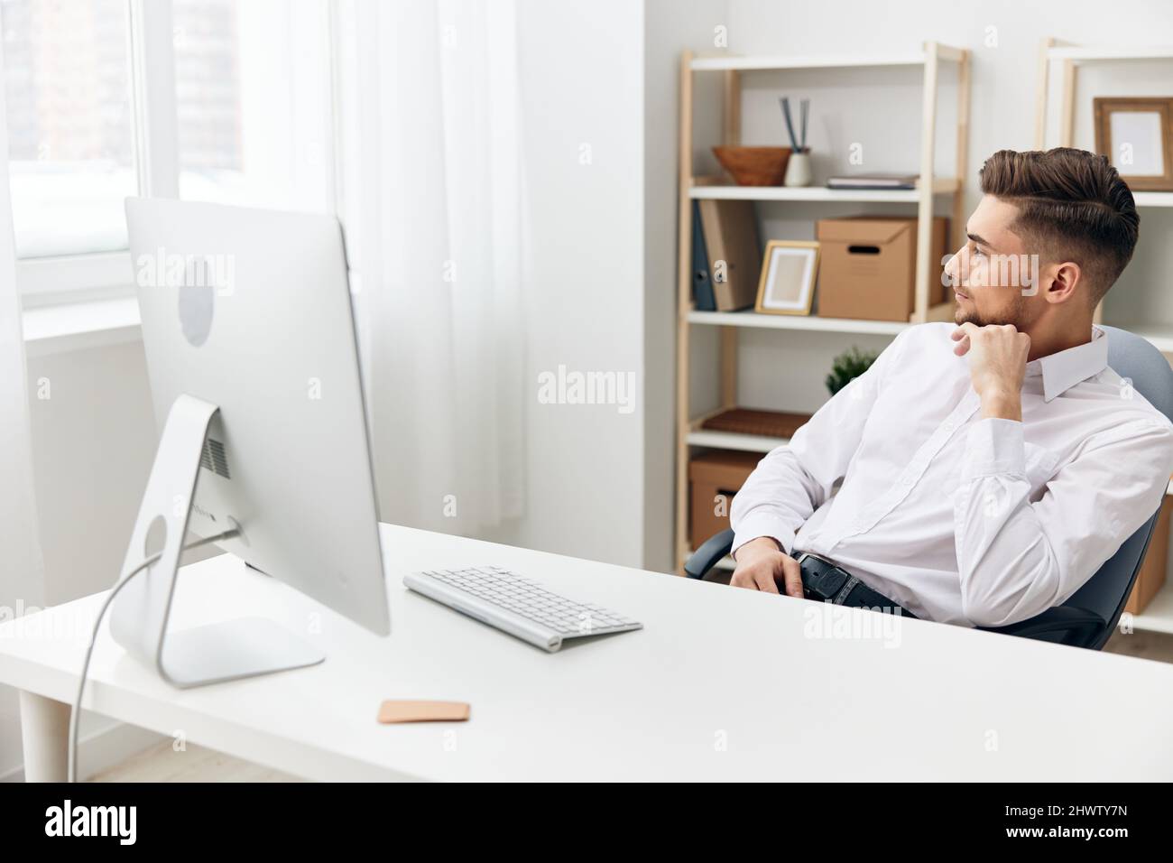 manager sitting at a desk in front of a computer with a keyboard ...
