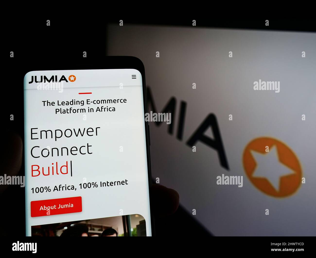 Person holding cellphone with websiteof Nigerian company Jumia Technologies on screen in front ...