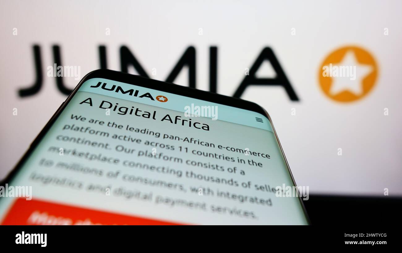 Mobile phone with webpage of Nigerian company Jumia Technologies on screen in front of business ...