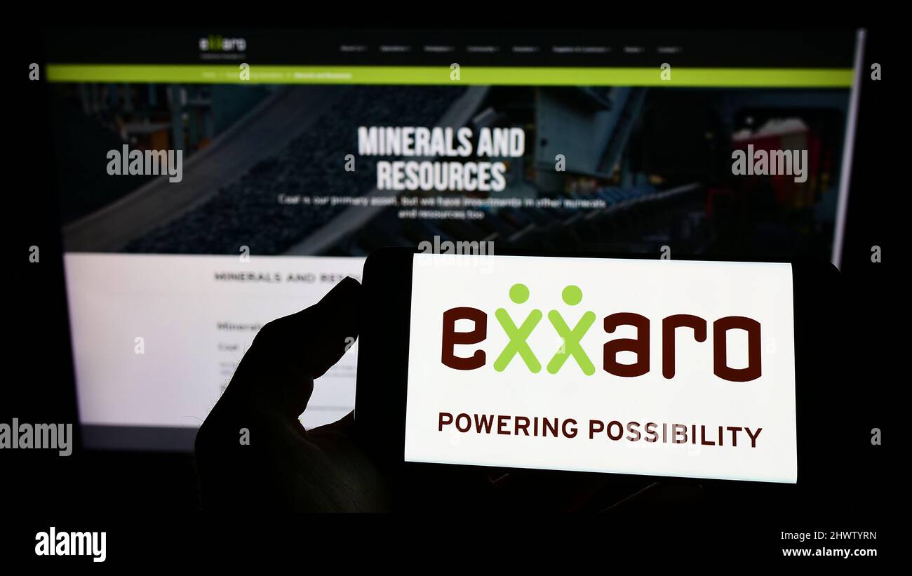 Person holding cellphone with logo of South African company Exxaro ...